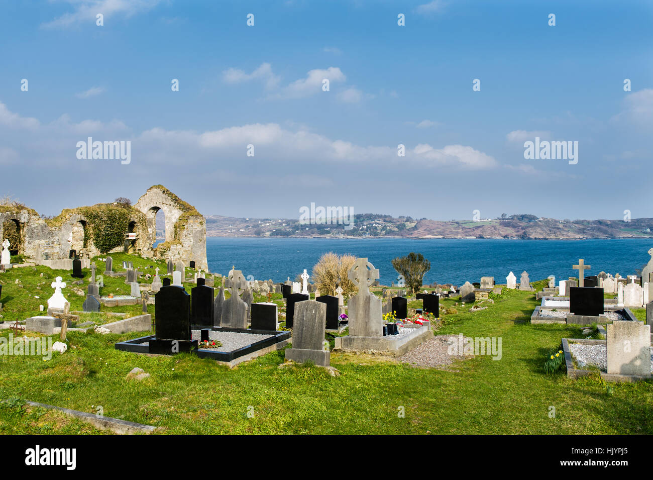Graveyard in Schull, West Cork, Ireland with church ruins on a clear ...