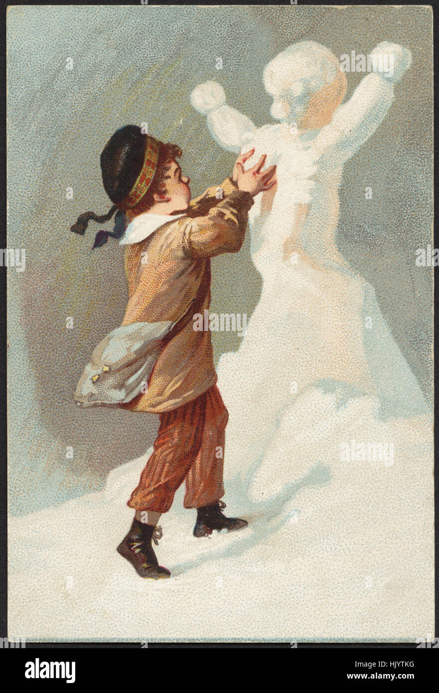 Boy building a snowman Stock Photo - Alamy