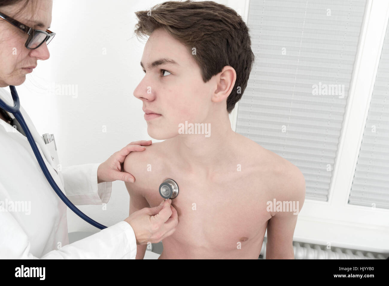 Female doctor examines teenage boy Stock Photo - Alamy