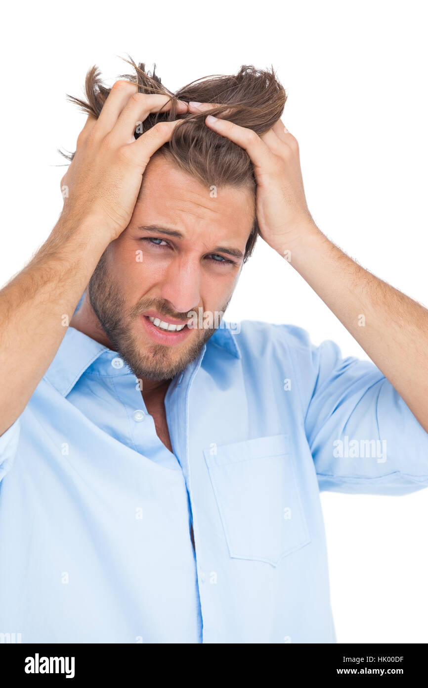 Tanned stressed man holding his hair on white background Stock Photo ...
