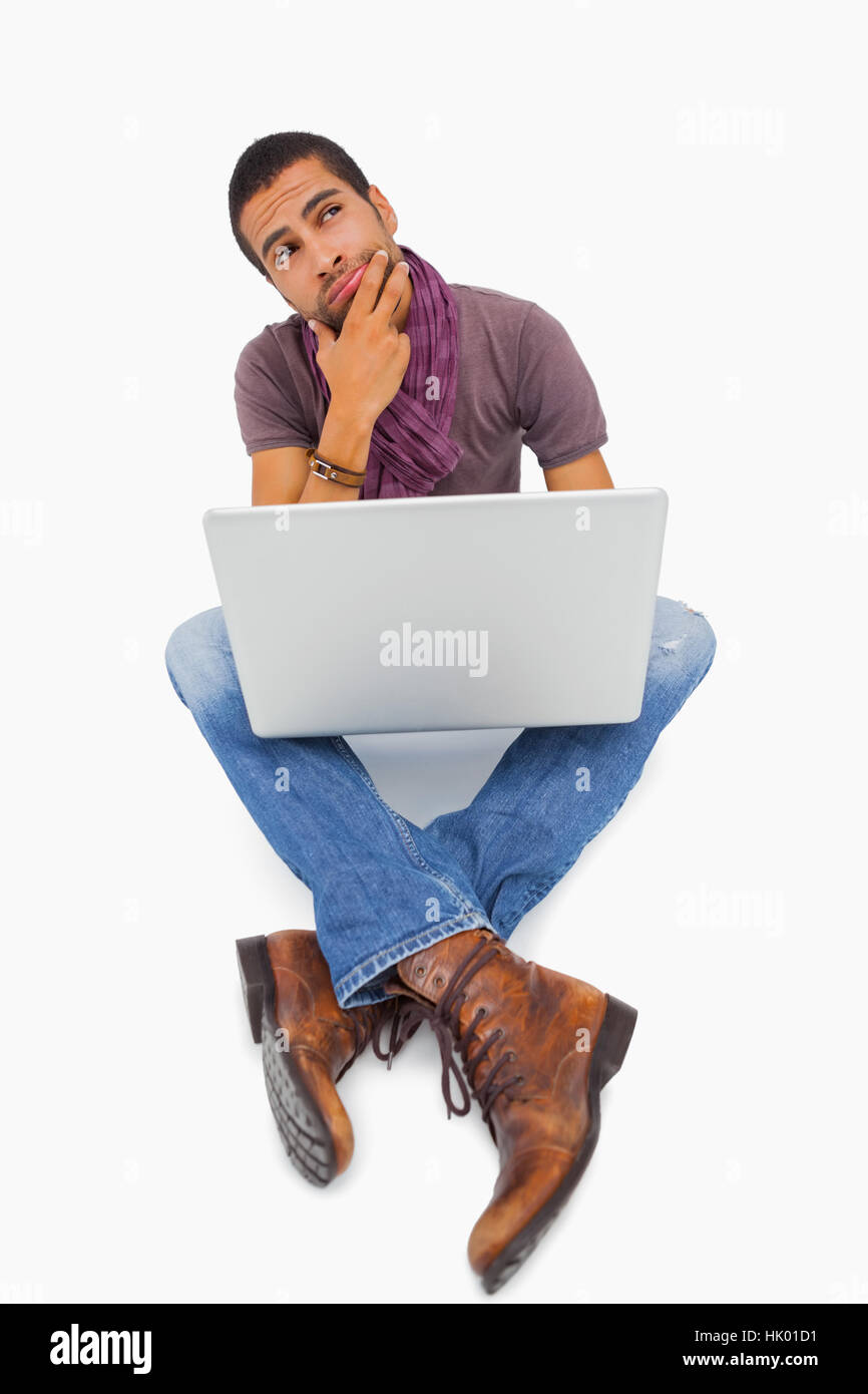 Thinking man sitting on floor using laptop on white background Stock ...