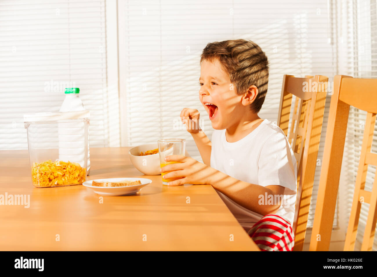 Happy little boy having healthy breakfast Stock Photo - Alamy