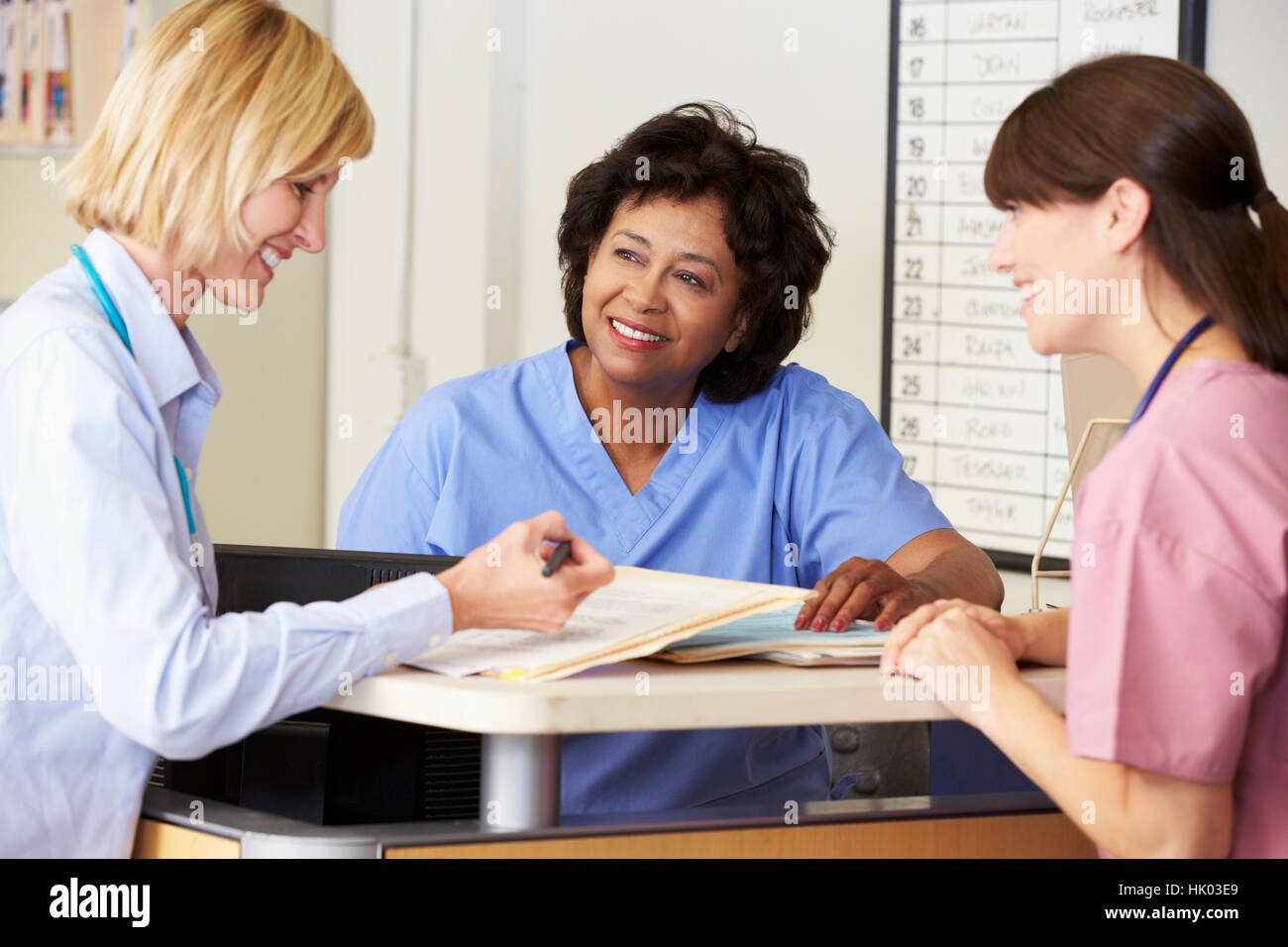 Doctor And Nurses In Discussion At Nurses Station Stock Photo - Alamy
