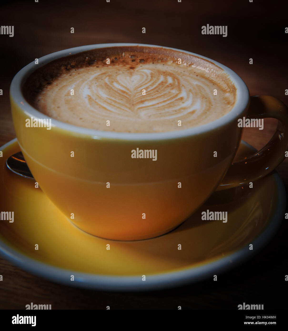Milky coffee in a yellow cup with pattern design Stock Photo - Alamy