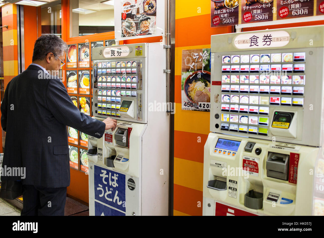 Man choosing meal from vending machine at a noodle restaurant in ...