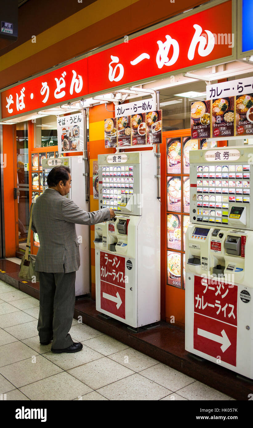 Man choosing meal from vending machine at a noodle restaurant in ...