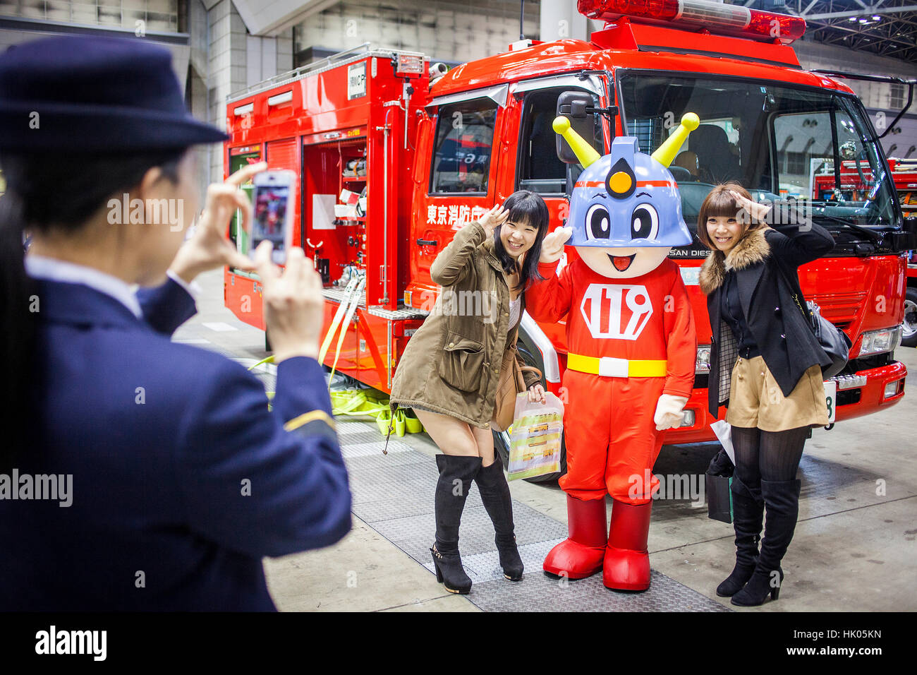 Firefighter taking picture of two girls with a Mascot of firefighters ...
