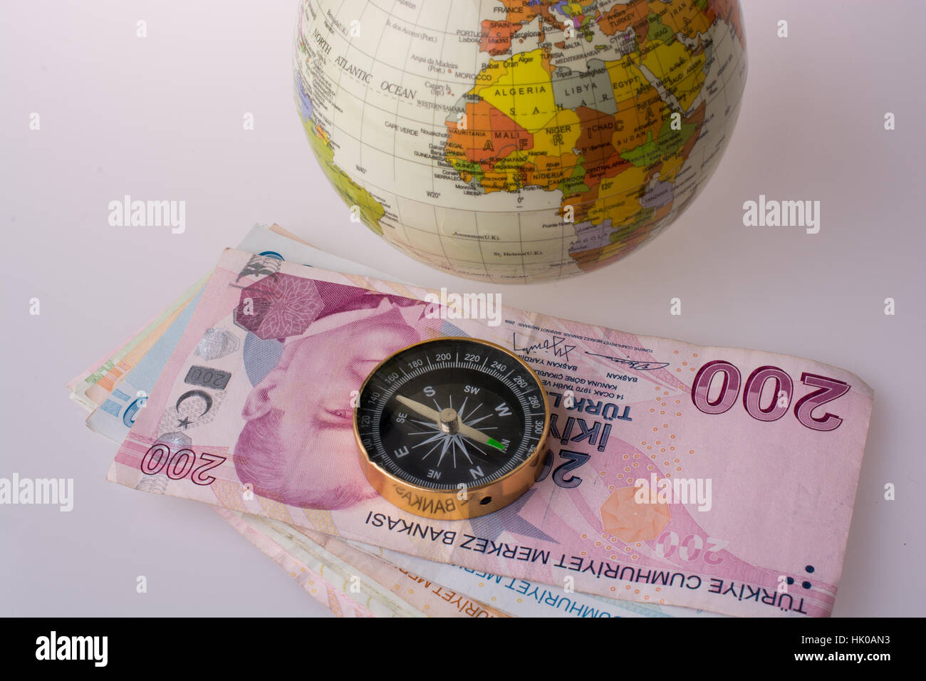 Turkish Lira banknotes by the side of a compass on white background ...
