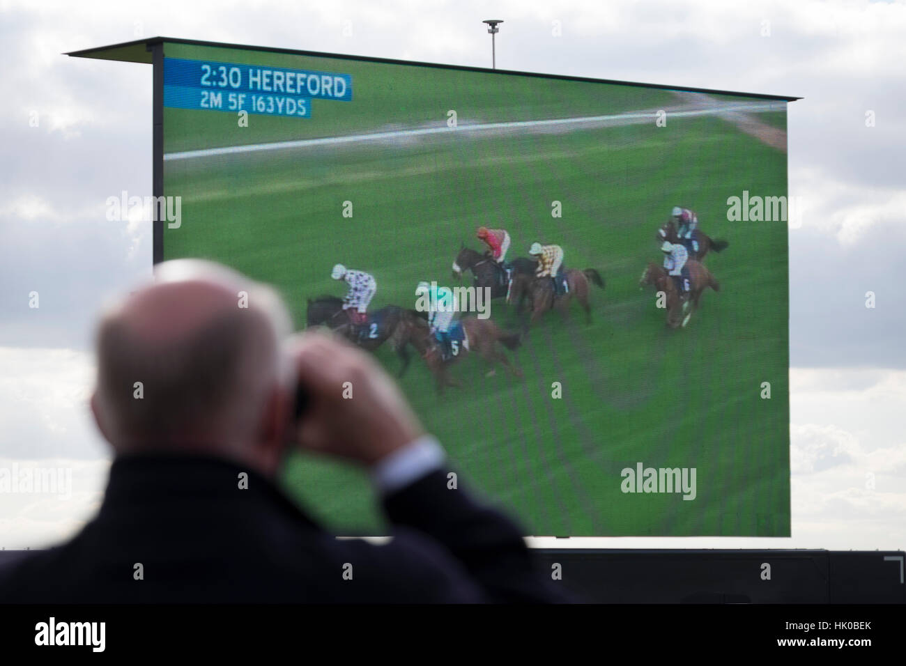 Man watching horse racing with binoculars Stock Photo - Alamy