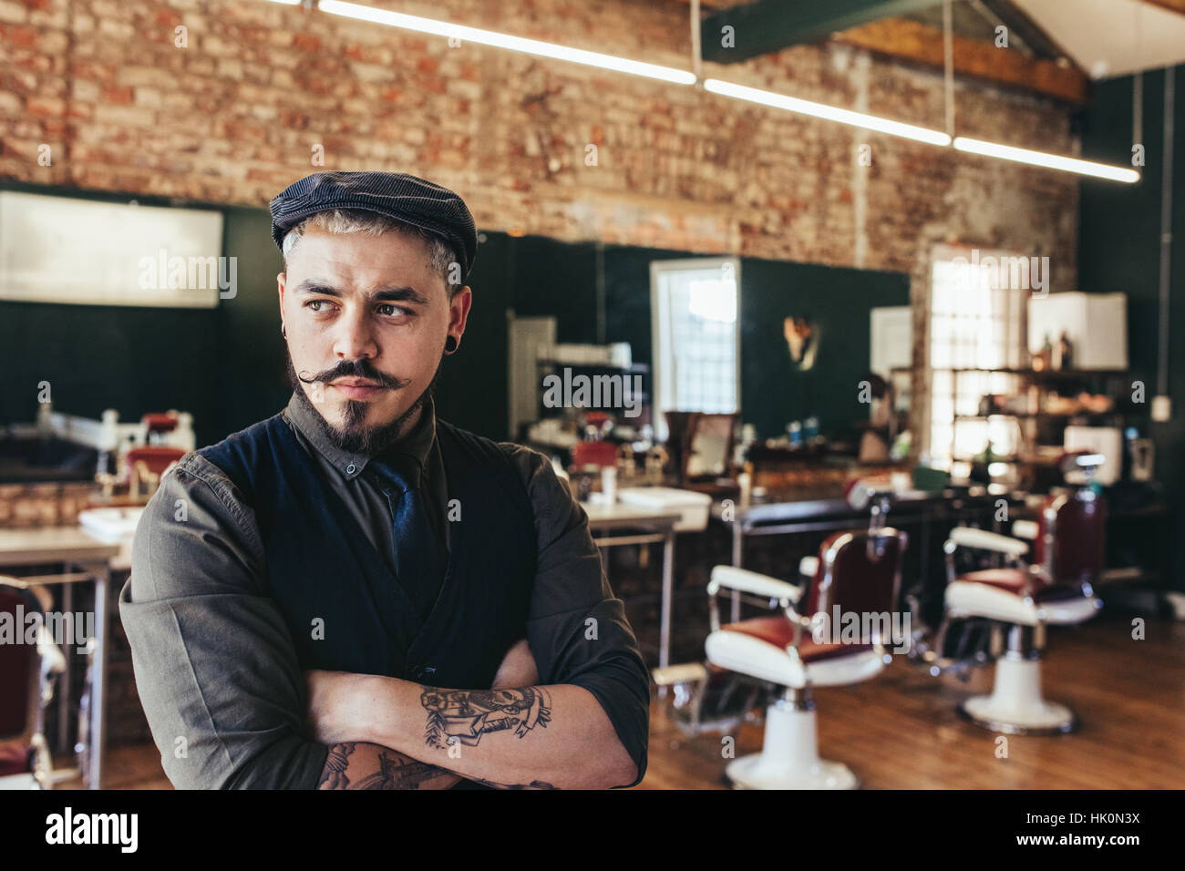 Portrait of handsome male barber looking away. Stylish hairdresser ...