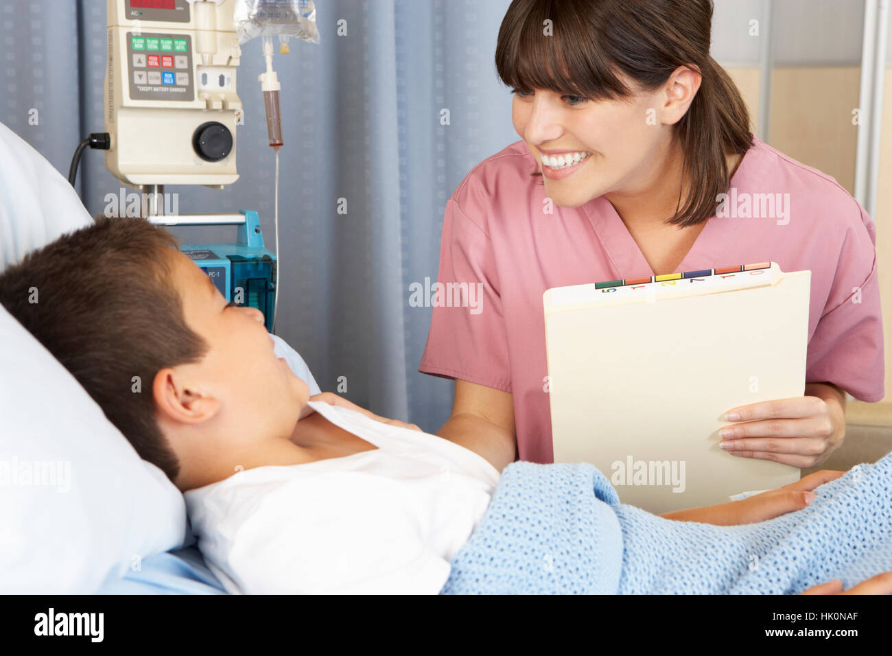 Nurse Visiting Child Patient On Ward Stock Photo - Alamy