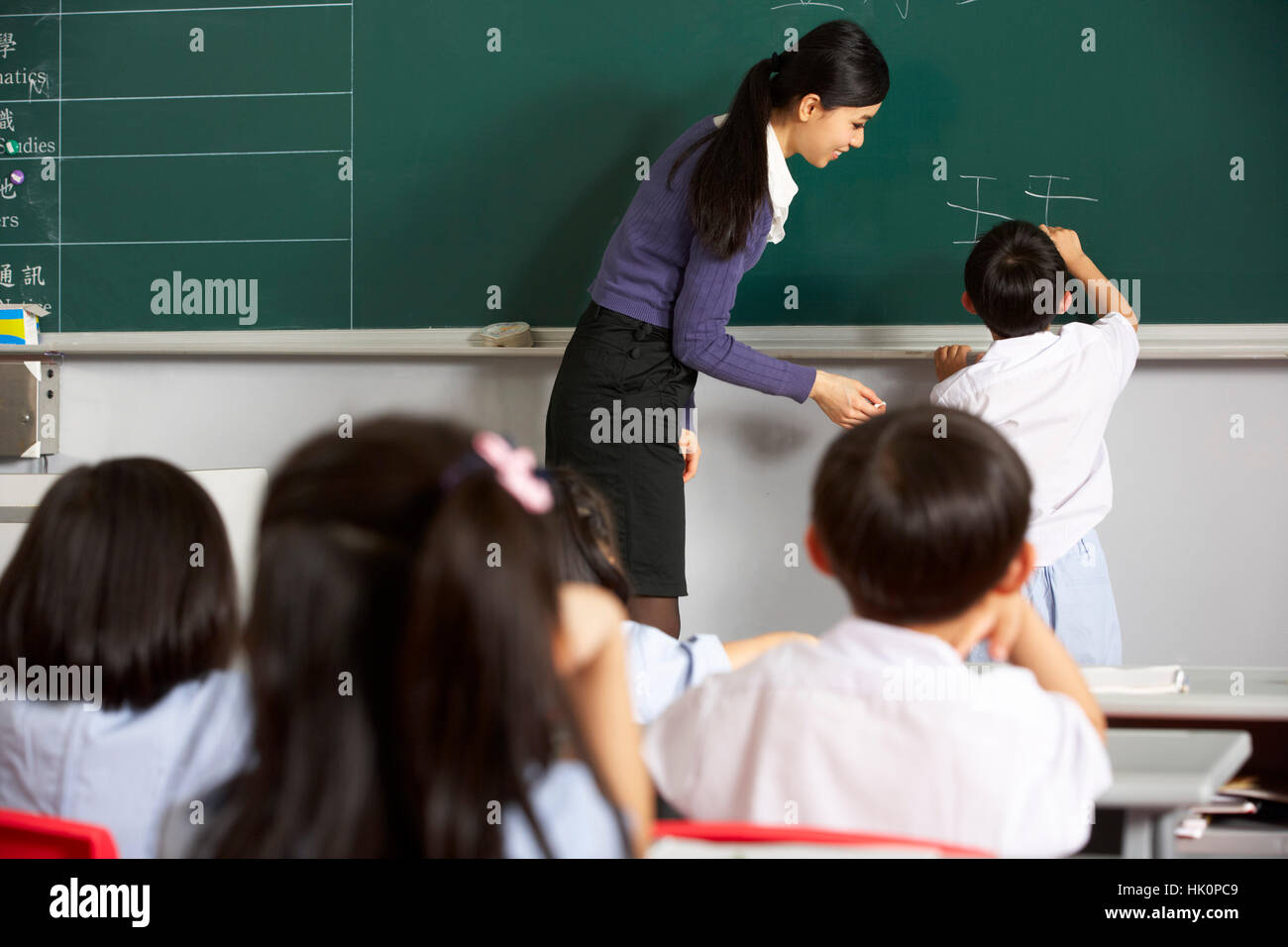 Male Pupil Writing On Blackboard In Chinese School Classroom Stock ...