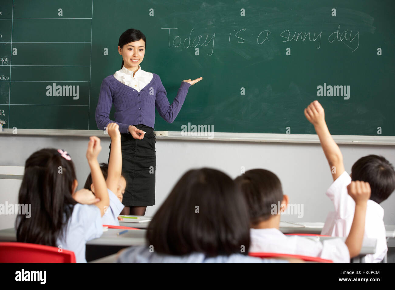 Teacher Standing By Blackboard In Chinese School Classroom Stock Photo ...