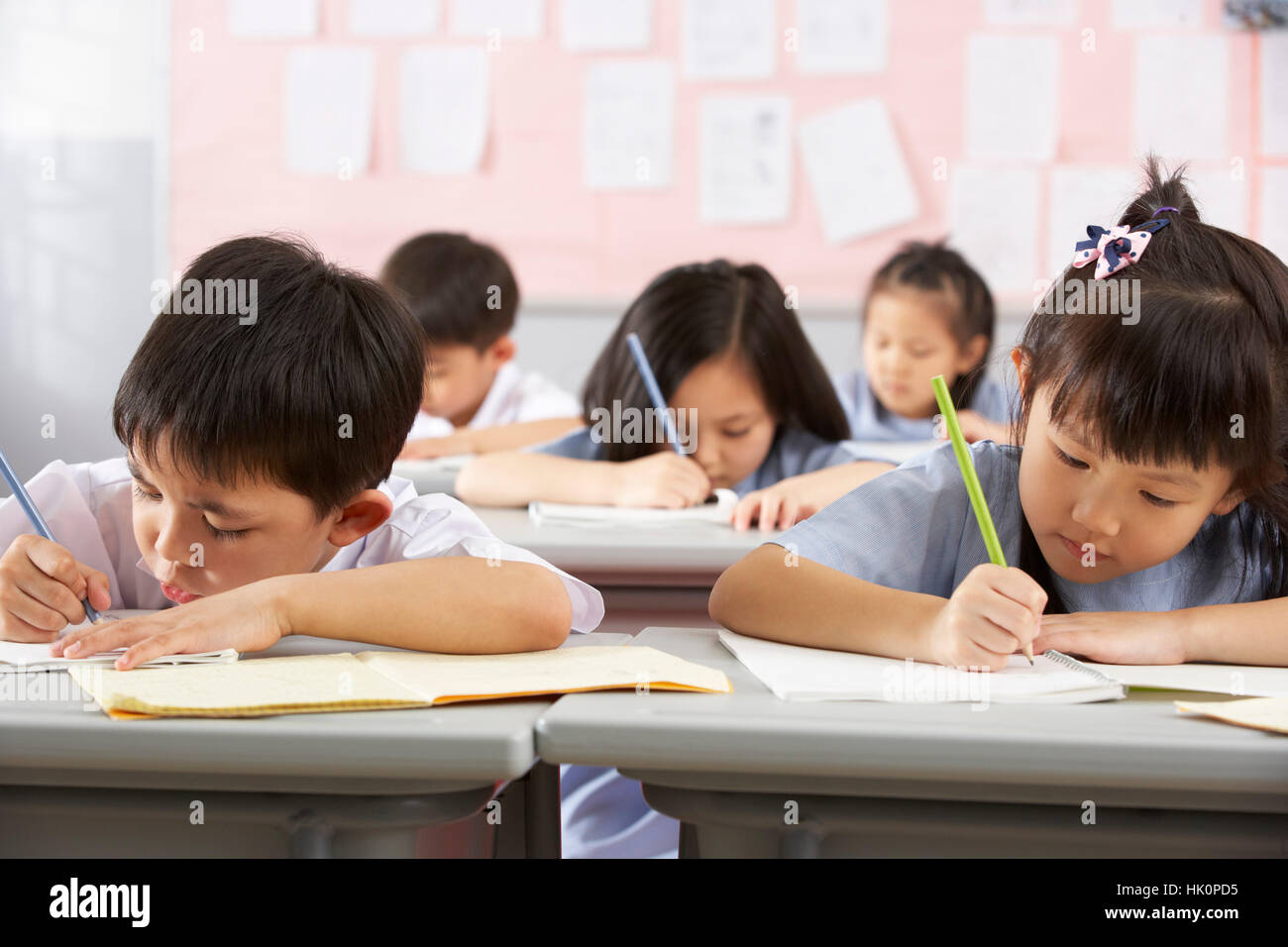 Group Of Students Working At Desks In Chinese School Classroom Stock ...