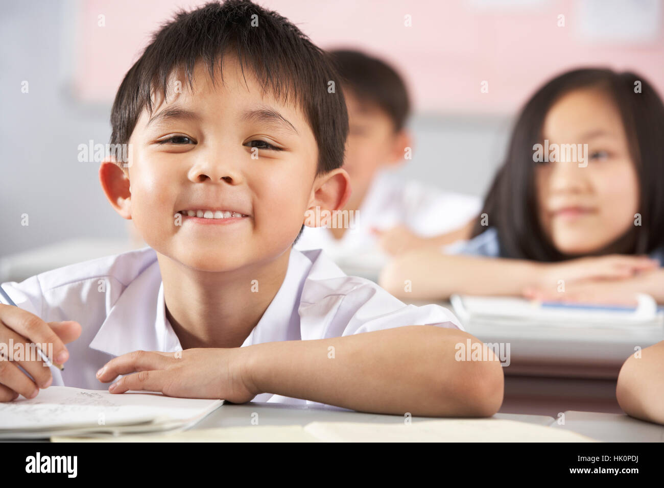 Group Of Students Working At Desks In Chinese School Classroom Stock ...