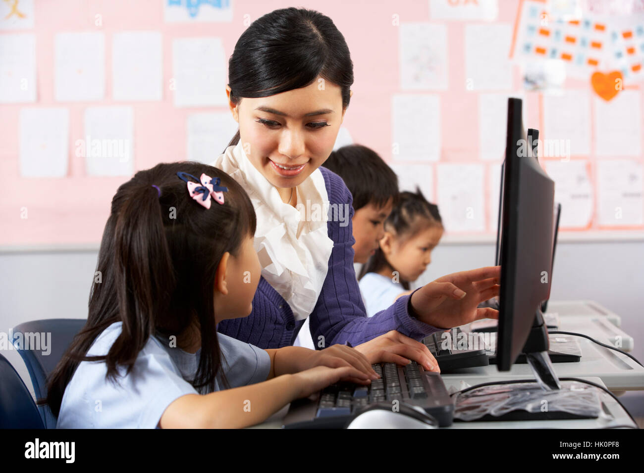Teacher Helping Student During Computer Class In Chinese School ...