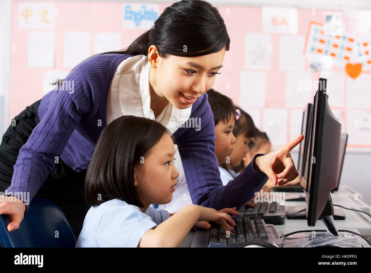 Teacher Helping Student During Computer Class In Chinese School ...
