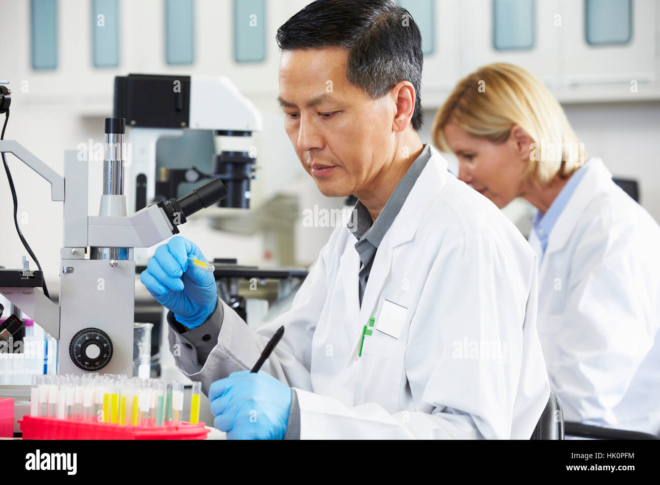 Male And Female Scientists Using Microscopes In Laboratory Stock Photo ...