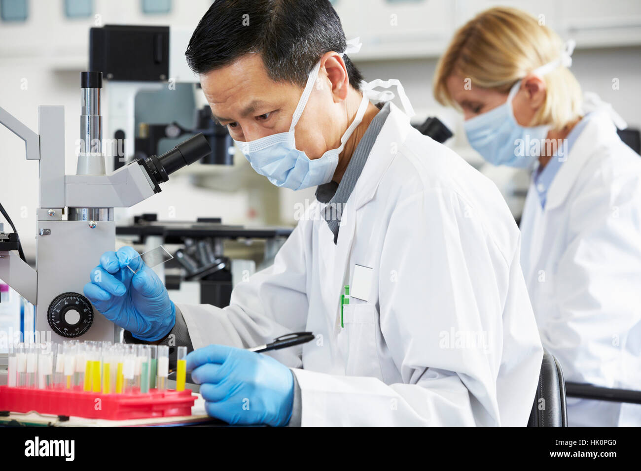 Male And Female Scientists Using Microscopes In Laboratory Stock Photo ...