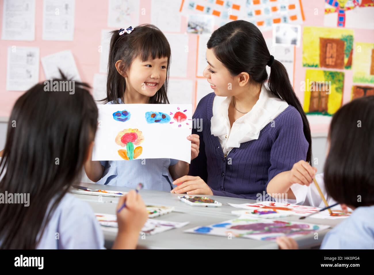 Teacher Helping Students During Art Class In Chinese School Classroom ...