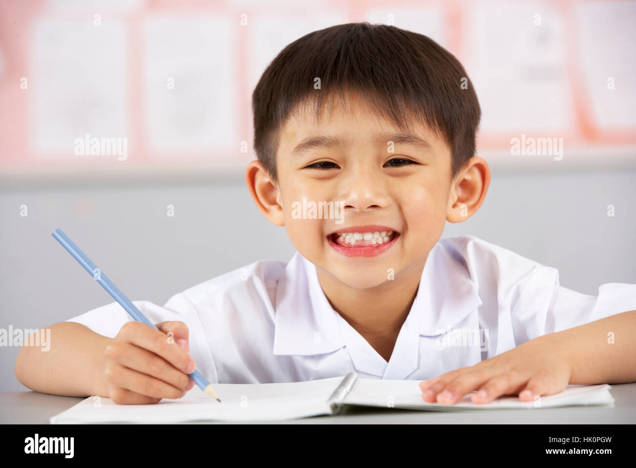 Male Student Working At Desk In Chinese School Classroom Stock Photo ...