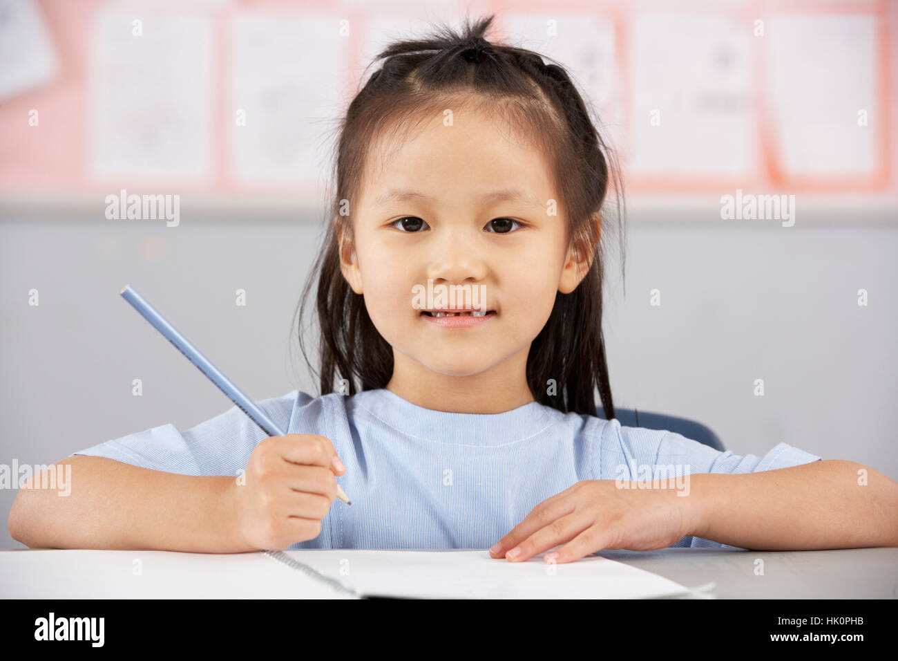 Female Student Working At Desk In Chinese School Classroom Stock Photo ...