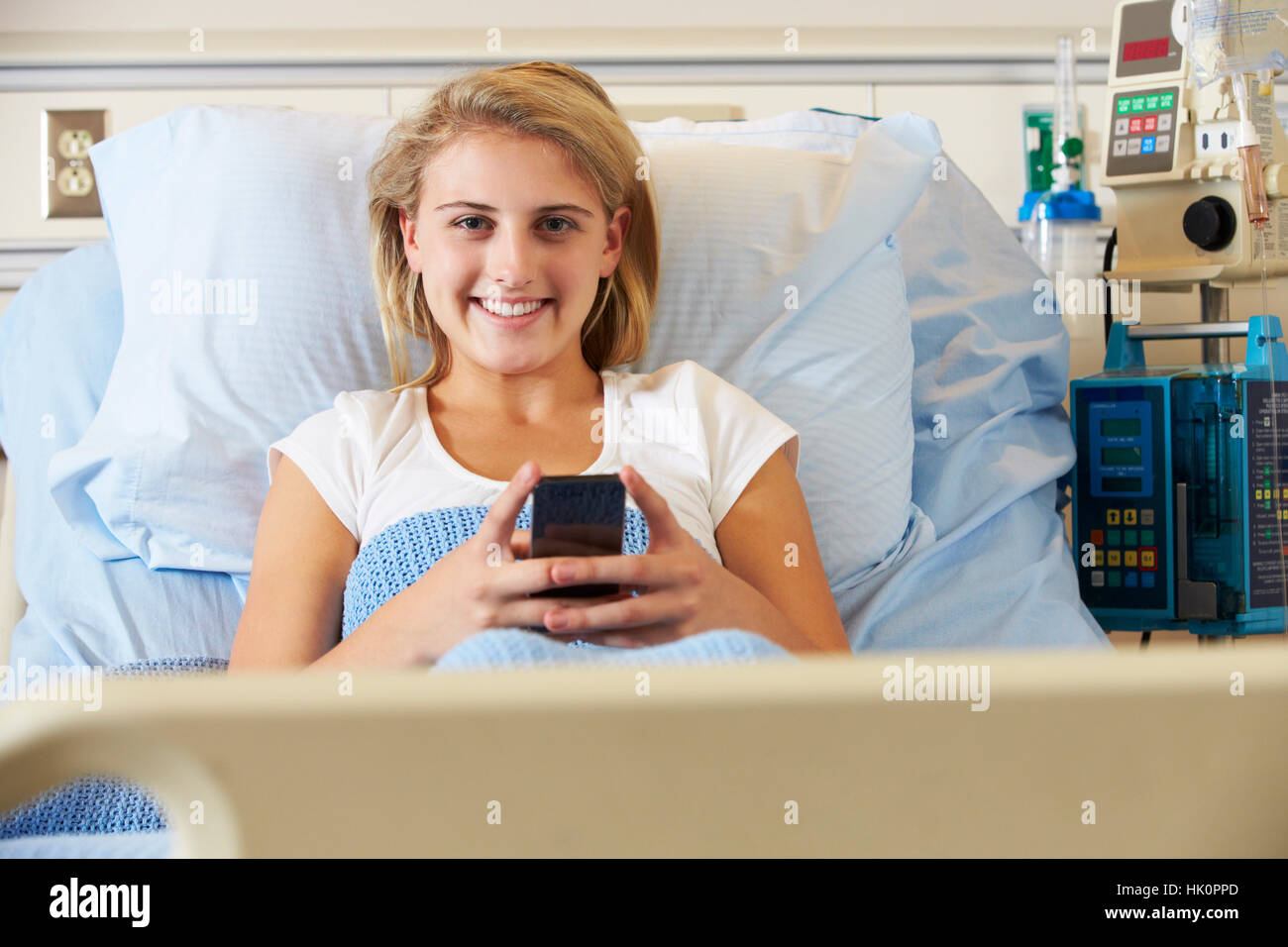 Teenage Female Patient Using Mobile Phone In Hospital Bed Stock Photo ...