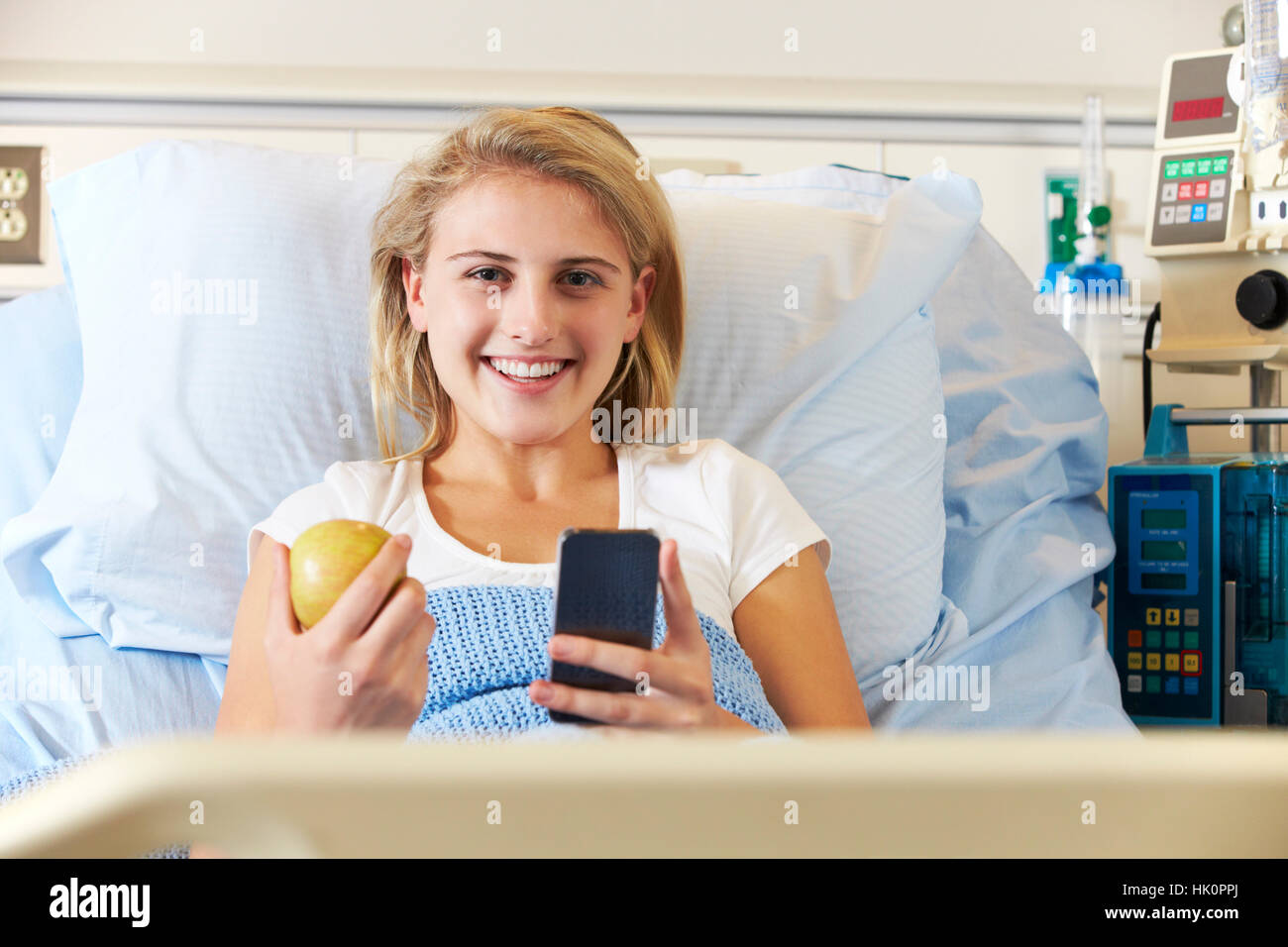 Teenage Female Patient Using Mobile Phone In Hospital Bed Stock Photo ...