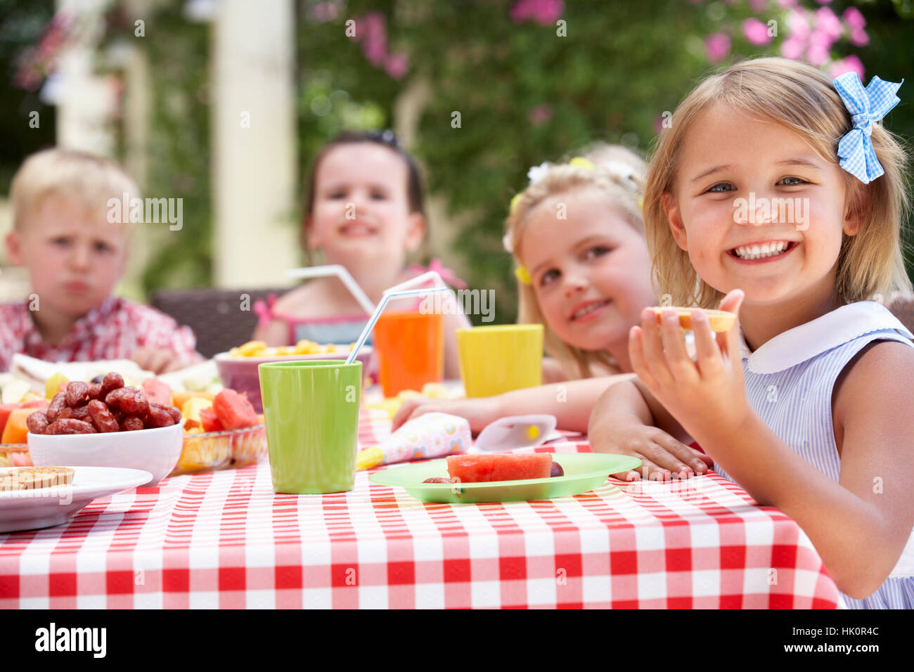 Group Of Children Enjoying Outdoor Tea Party Stock Photo - Alamy