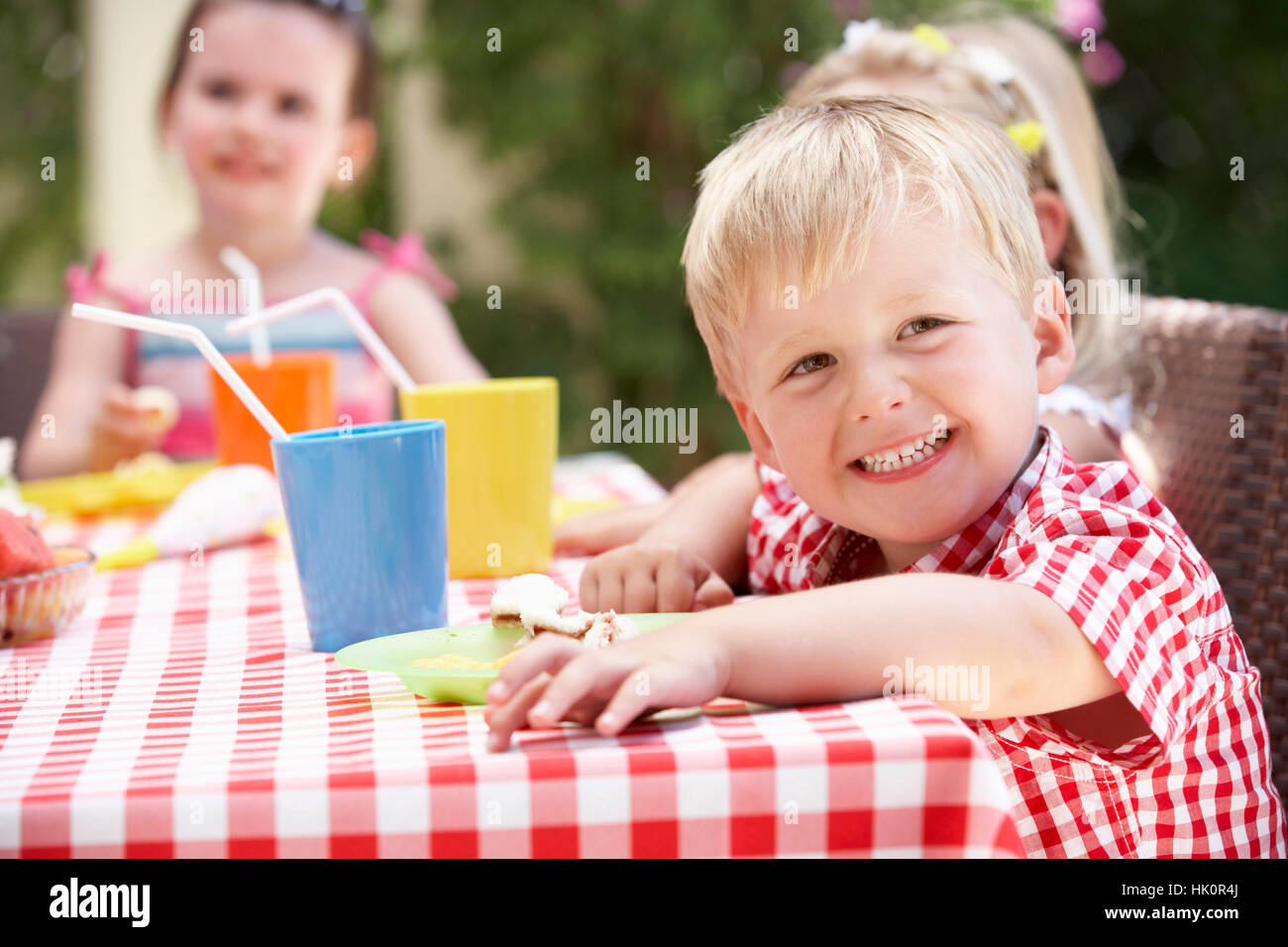 Group Of Children Enjoying Outdoor Tea Party Stock Photo - Alamy