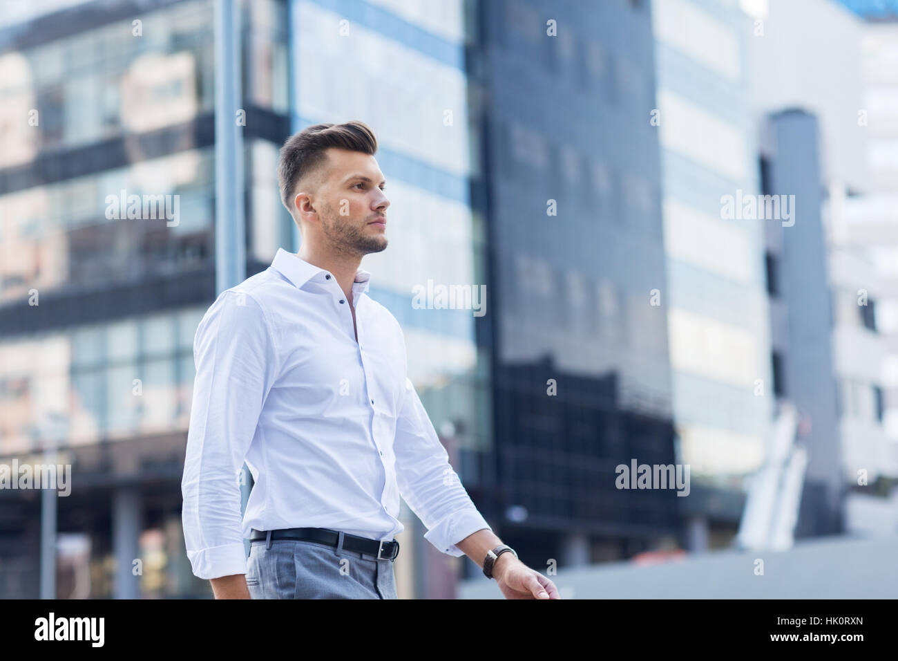 young man walking along city street Stock Photo - Alamy