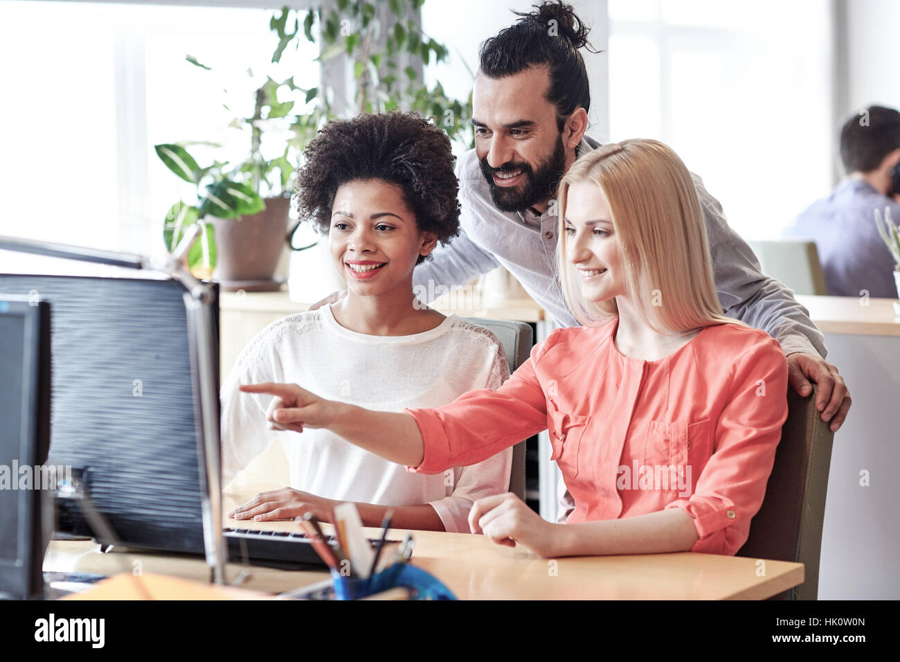 happy creative team with computer in office Stock Photo - Alamy