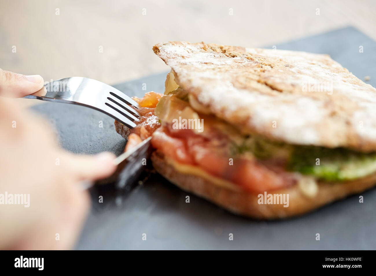 person eating salmon panini sandwich at restaurant Stock Photo - Alamy