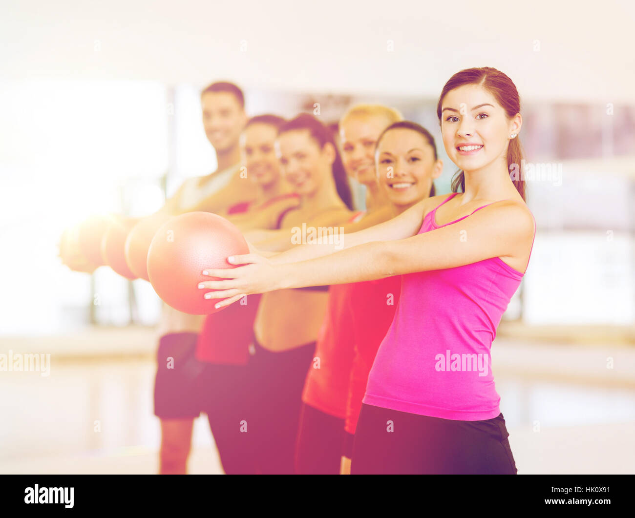 group of smiling people working out with ball Stock Photo - Alamy