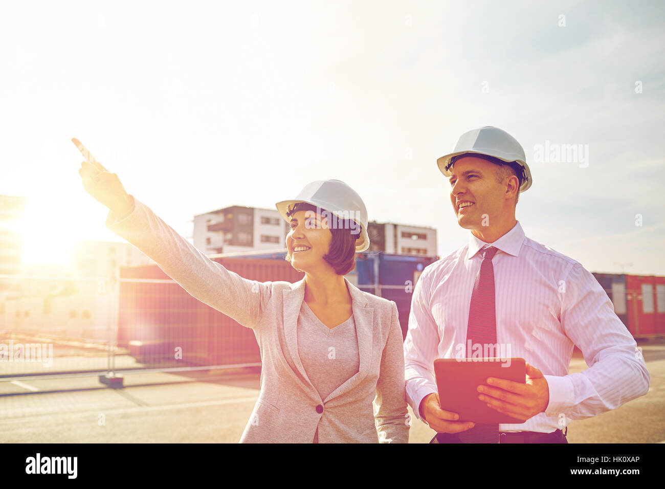 happy builders in hardhats with tablet pc outdoors Stock Photo - Alamy