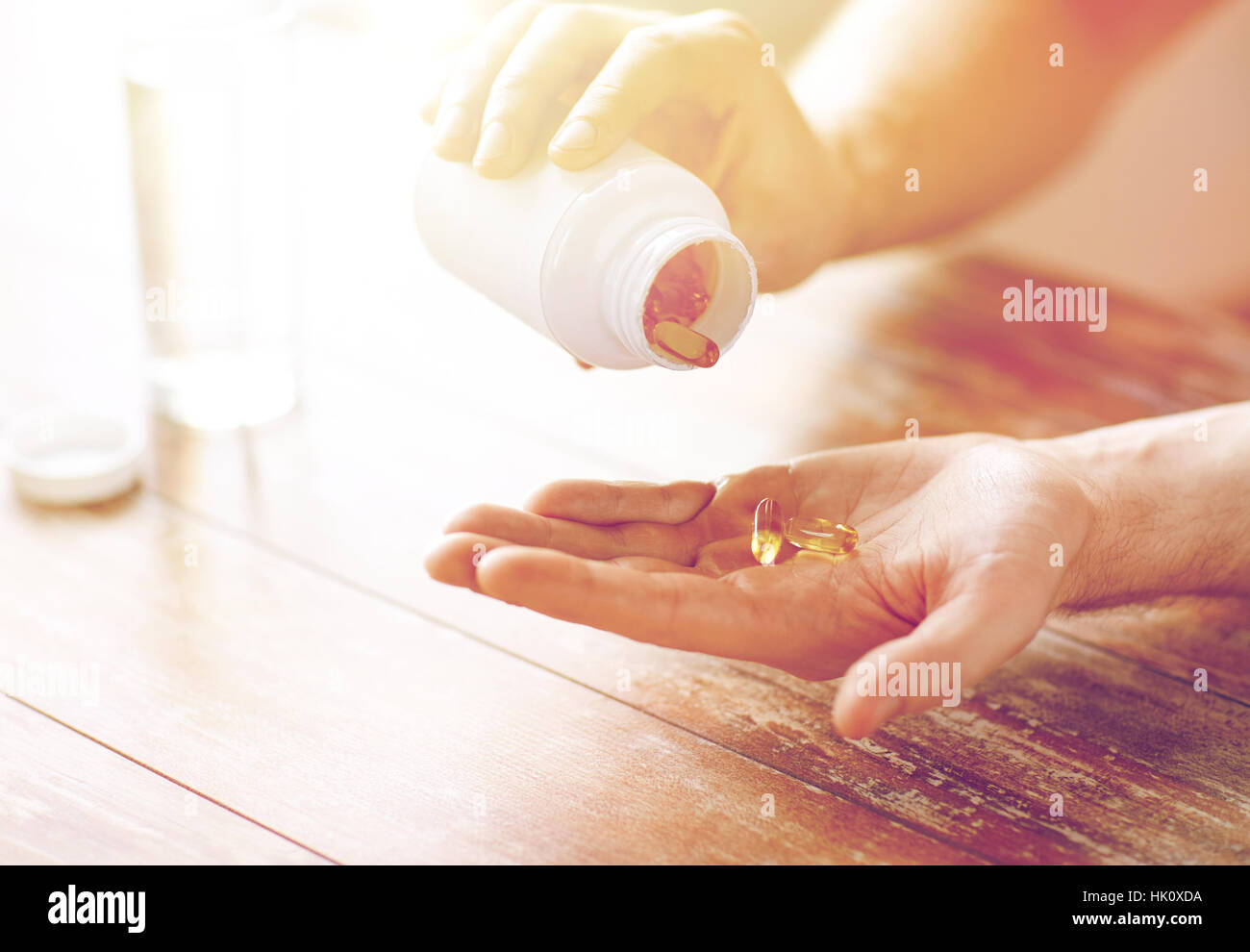close up of man pouring fish oil capsules to hand Stock Photo - Alamy