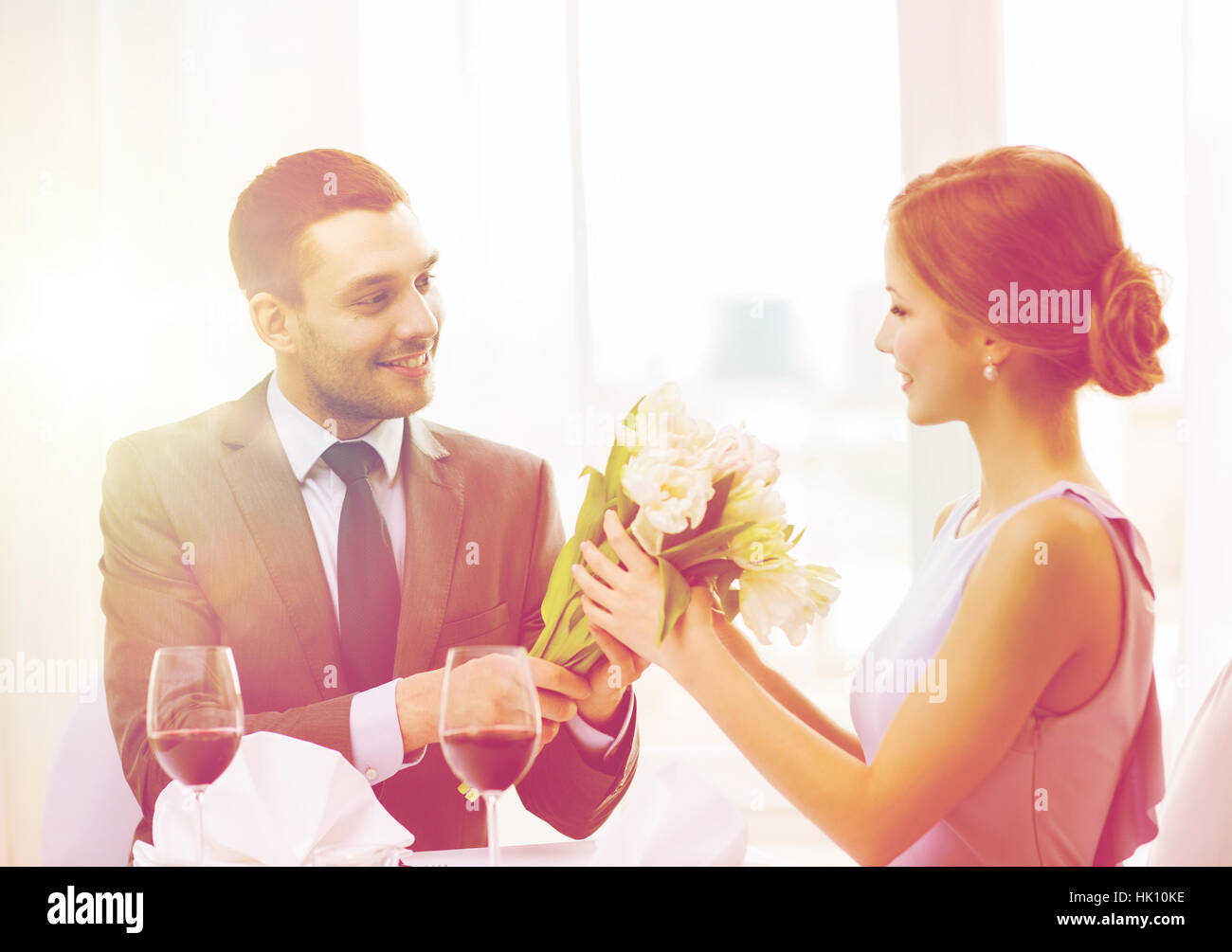 smiling man giving flower bouquet at restaurant Stock Photo - Alamy