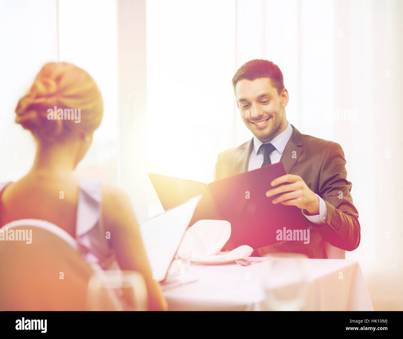 smiling young man looking at menu at restaurant Stock Photo - Alamy