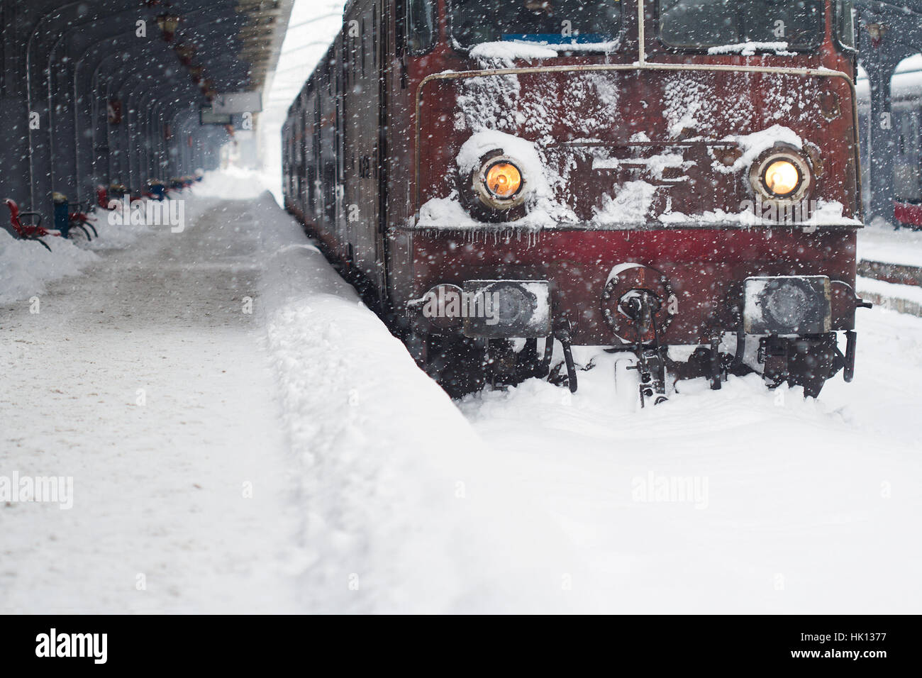 perspective view of the front red locomotive of a passenger train with ...