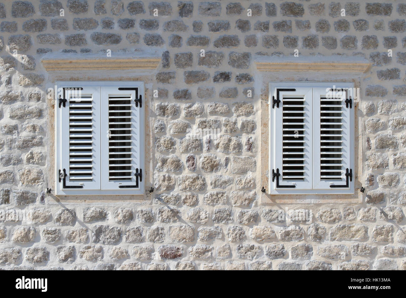 Two shuttered windows in the stone wall of the house, horizontal Stock ...