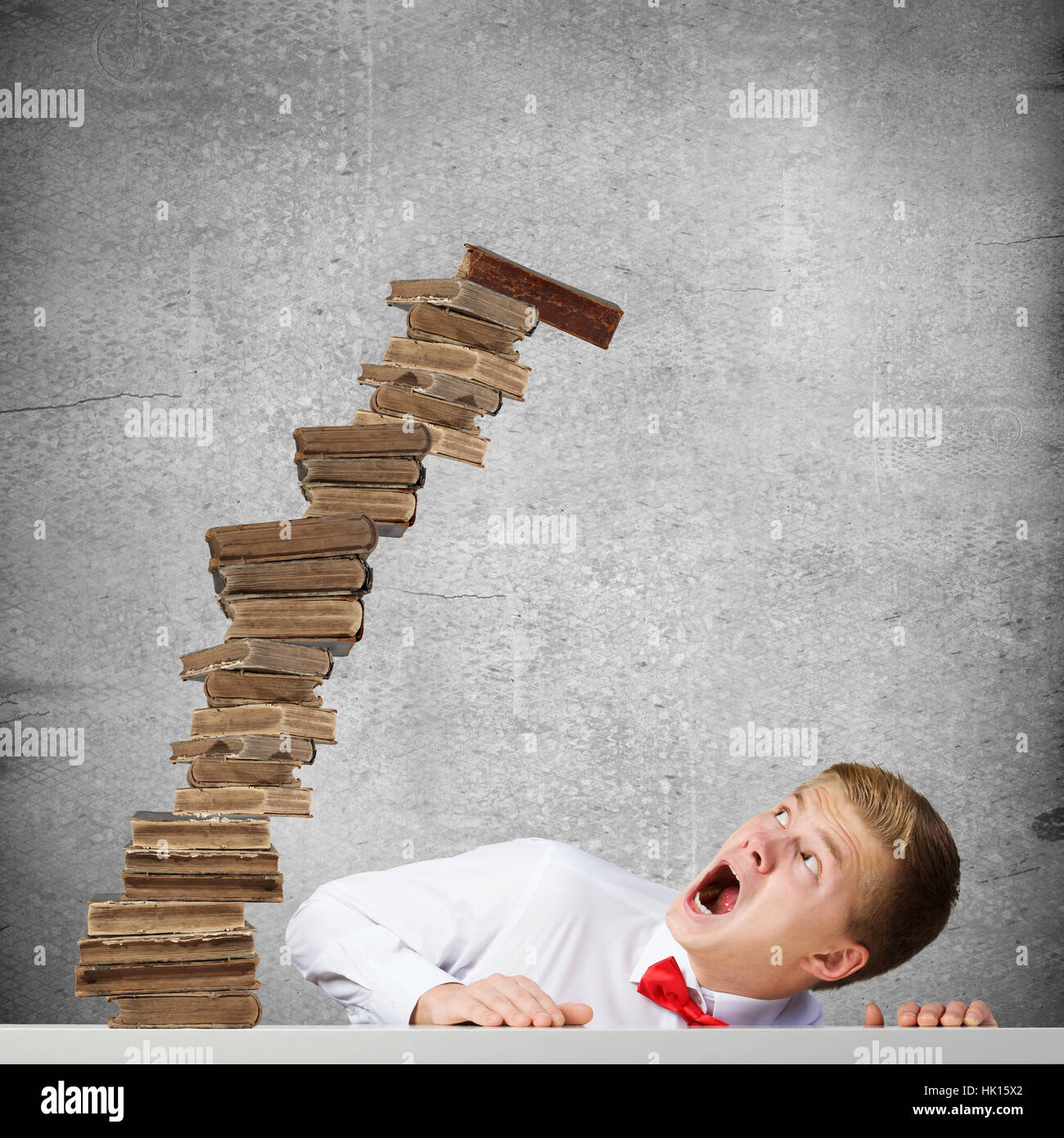 Young handsome businessman and falling pile of books hi-res stock ...