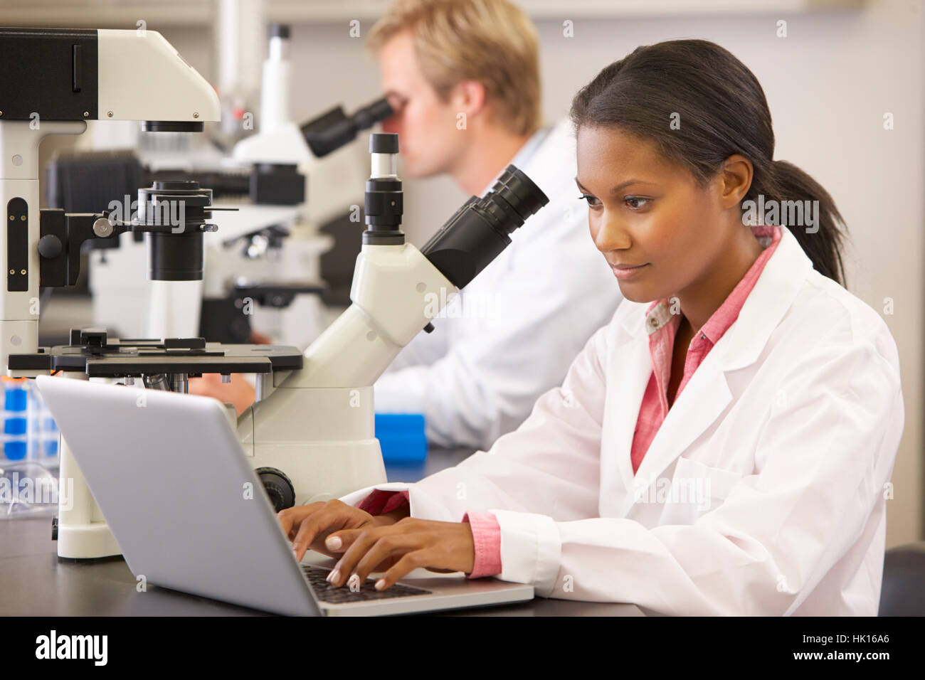 Male And Female Scientists Using Microscopes In Laboratory Stock Photo ...