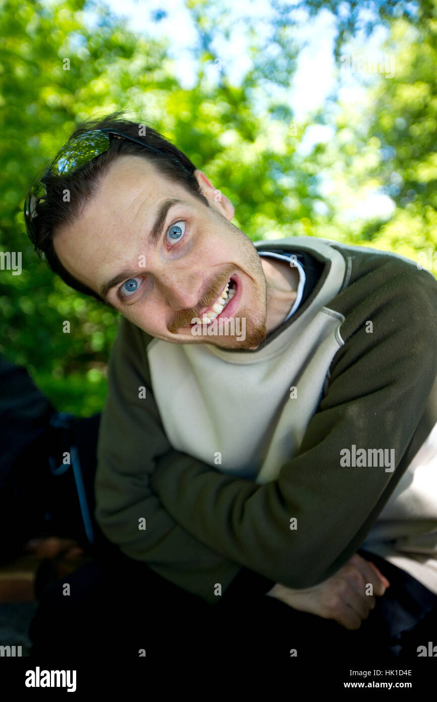 Man sitting and putting crazy expression Stock Photo - Alamy