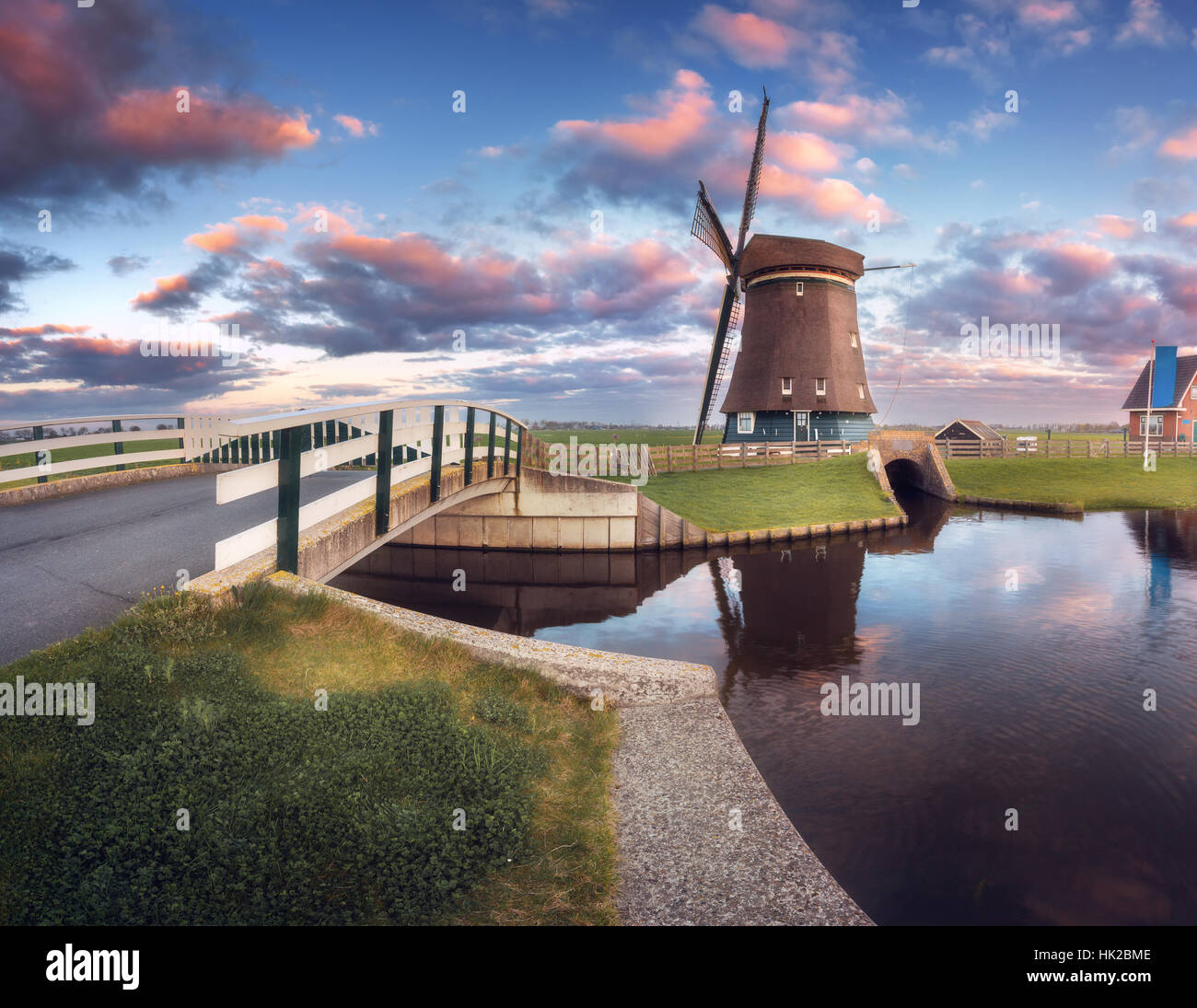 Windmill and bridge near the water canal at sunrise in Netherlands ...