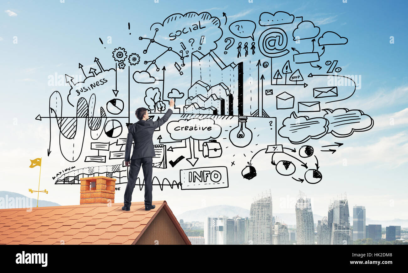 Rear view of businessman on house roof drawing his new business Stock ...