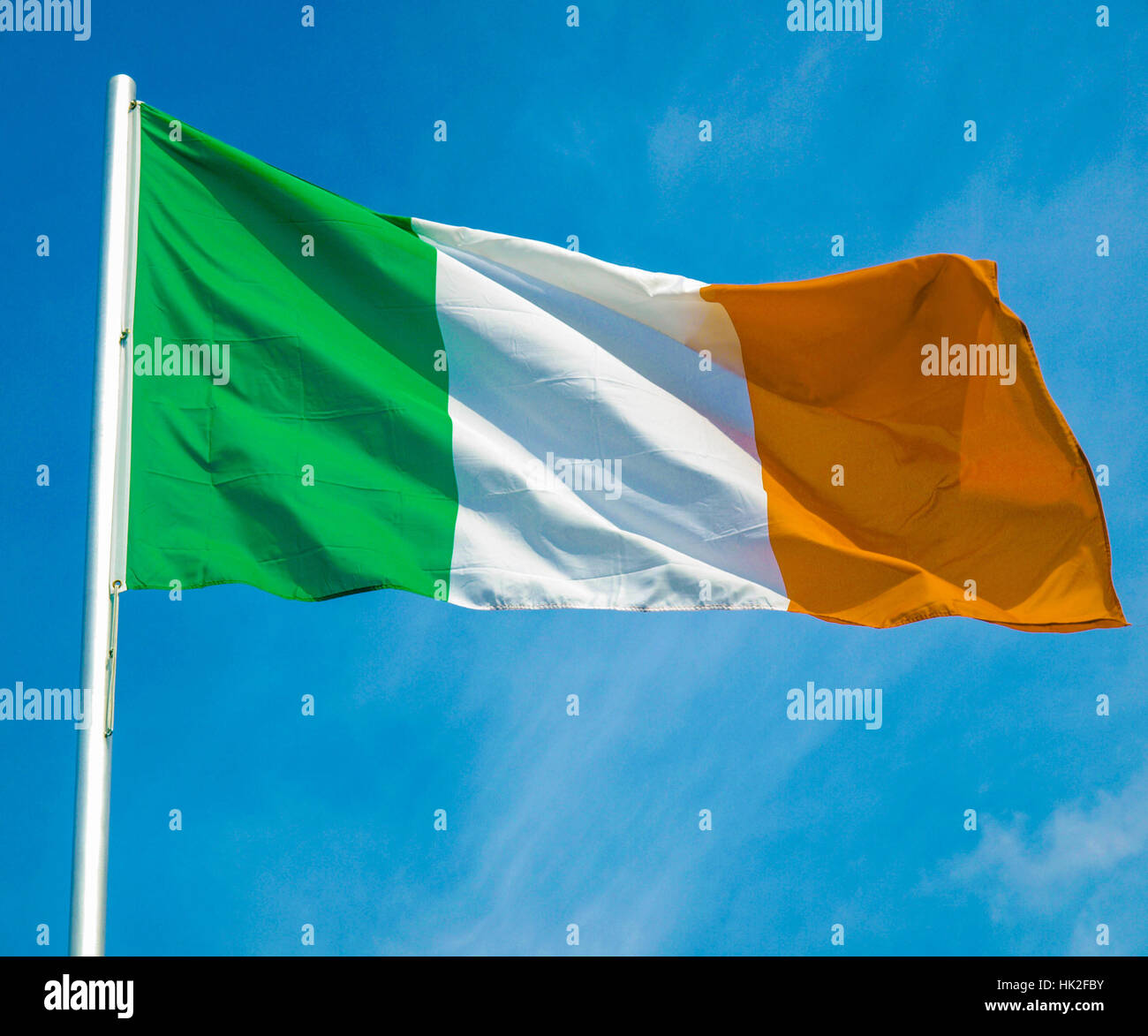 Irish flag over a blue sky background Stock Photo - Alamy