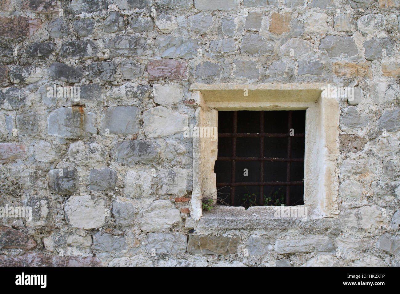Small old square window with bars in a stone wall Stock Photo - Alamy