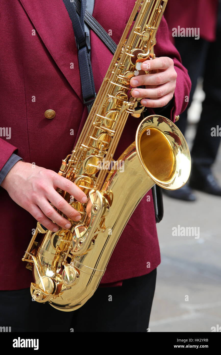 player plays the saxophone in the brass bas outside Stock Photo - Alamy