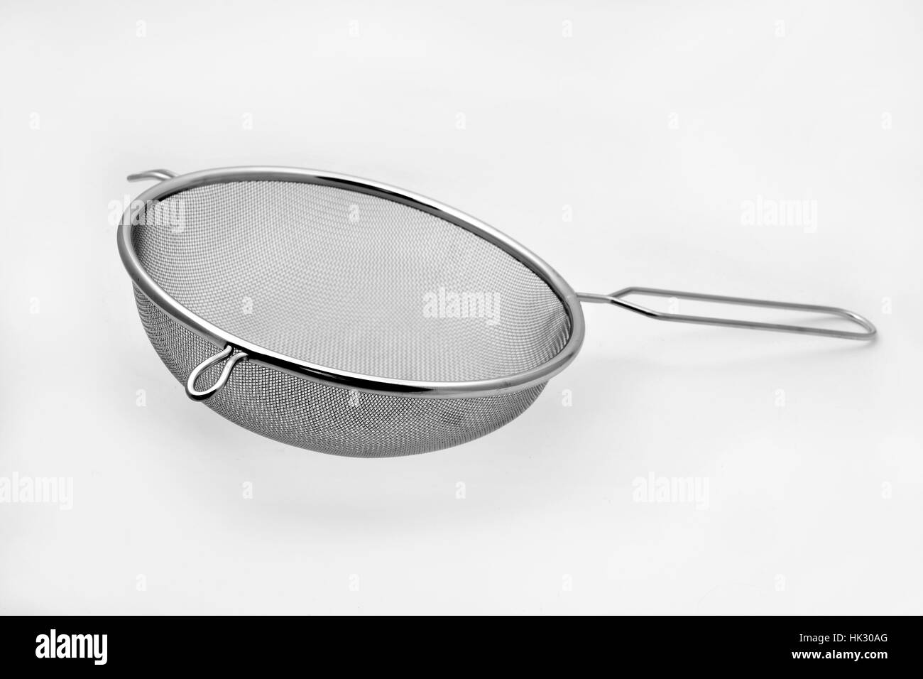 an stainless steel mesh strainer on an off-white background Stock Photo ...