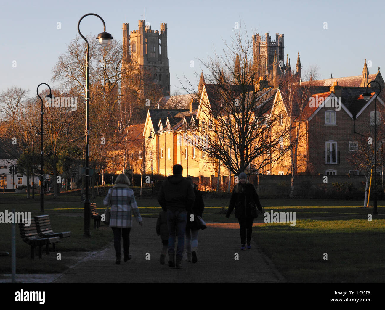 Pedestrians walk through Jubilee Gardens in Ely with the Cathedral seen ...